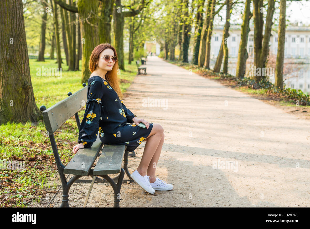 Girl sitting alone on a bench Stock Photo - Alamy