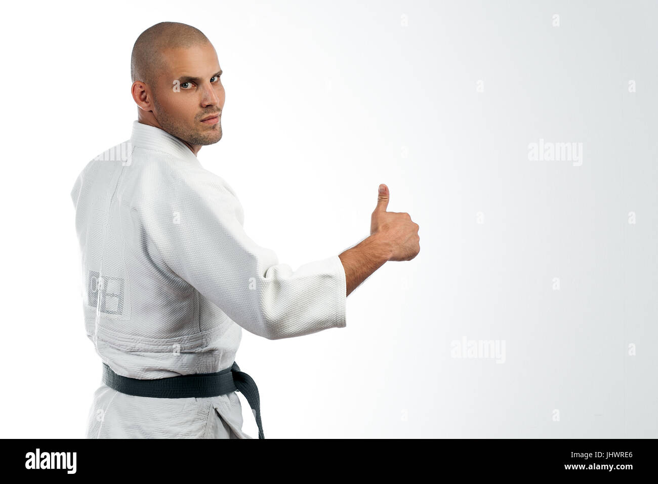 Young man fighter in white kimono for judo, jujitsu posing on isolated ...