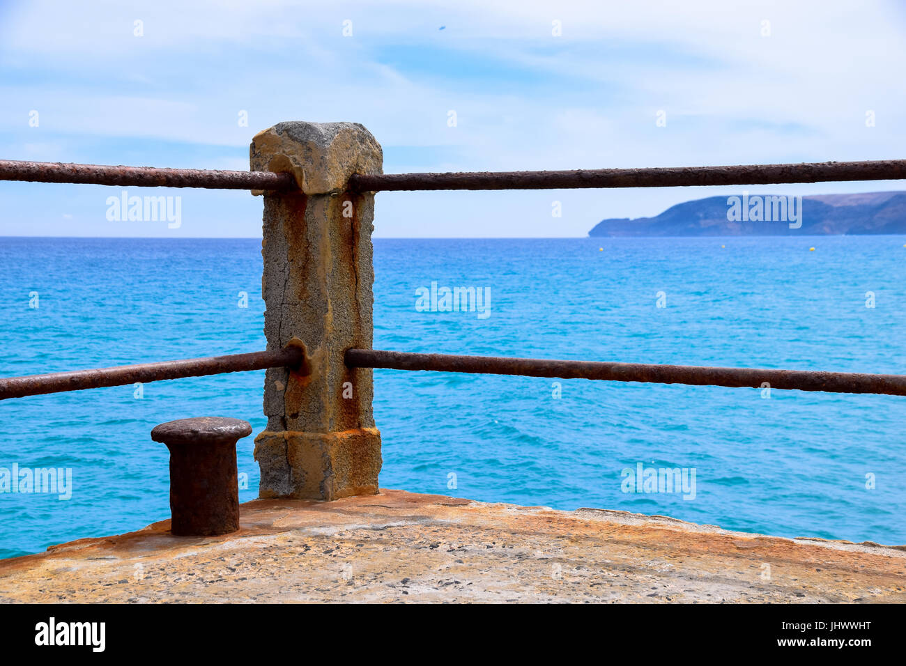 Concrete post of rusty ship bollard at the end of a concrete pier ...