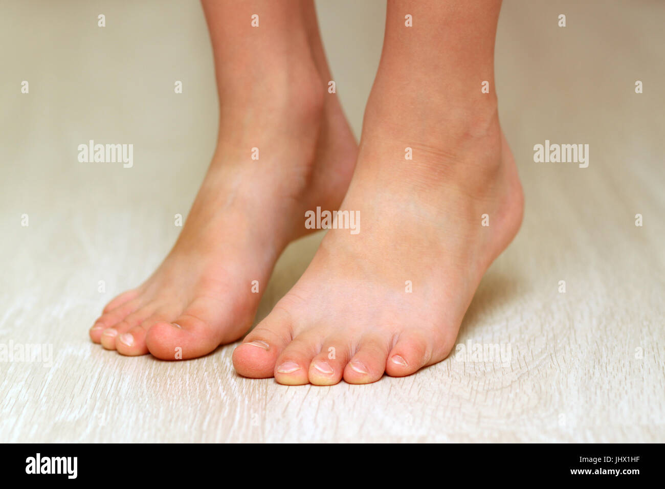 Child's feet on parquet laminate wooden texture floor close-up ...