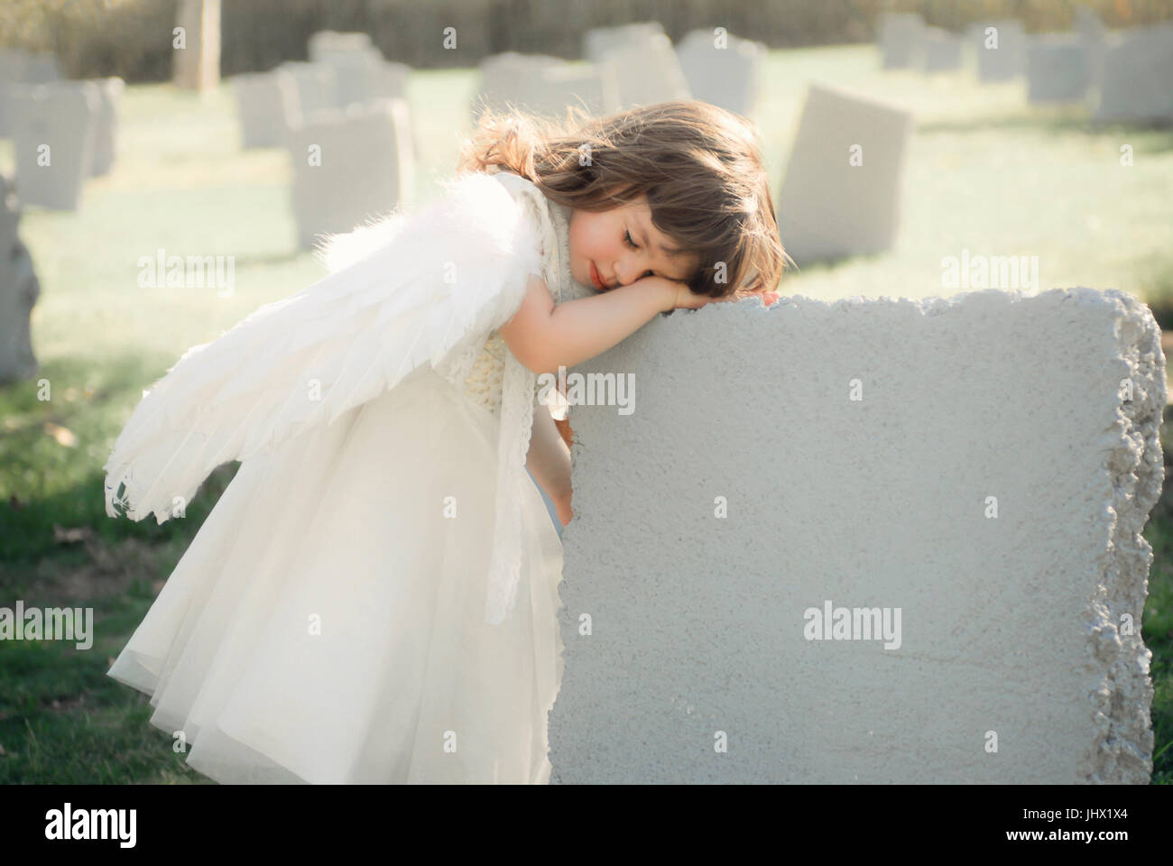 Angel child leaning on blank tombstone Stock Photo - Alamy