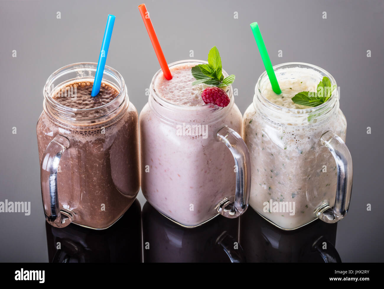 Milkshake in jar with a straw on black background Stock Photo - Alamy