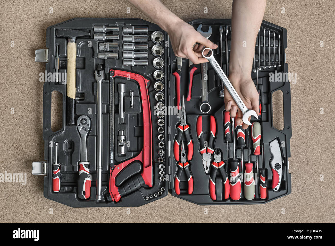 Black toolbox on the light tabletop in the workshop. Man with a tattoo ...
