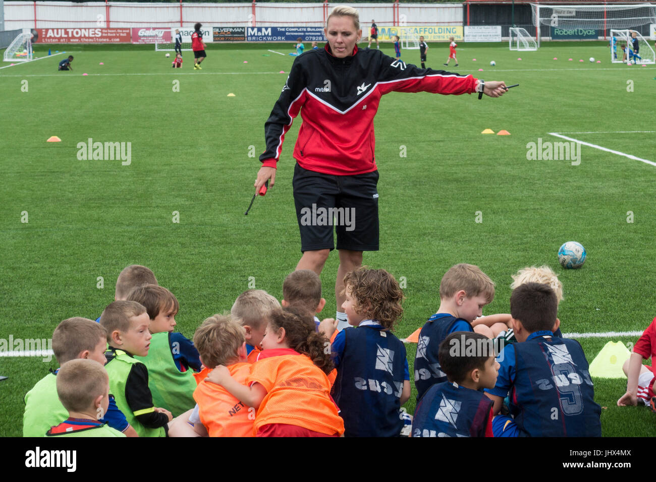 Female football coach teaching children Stock Photo - Alamy