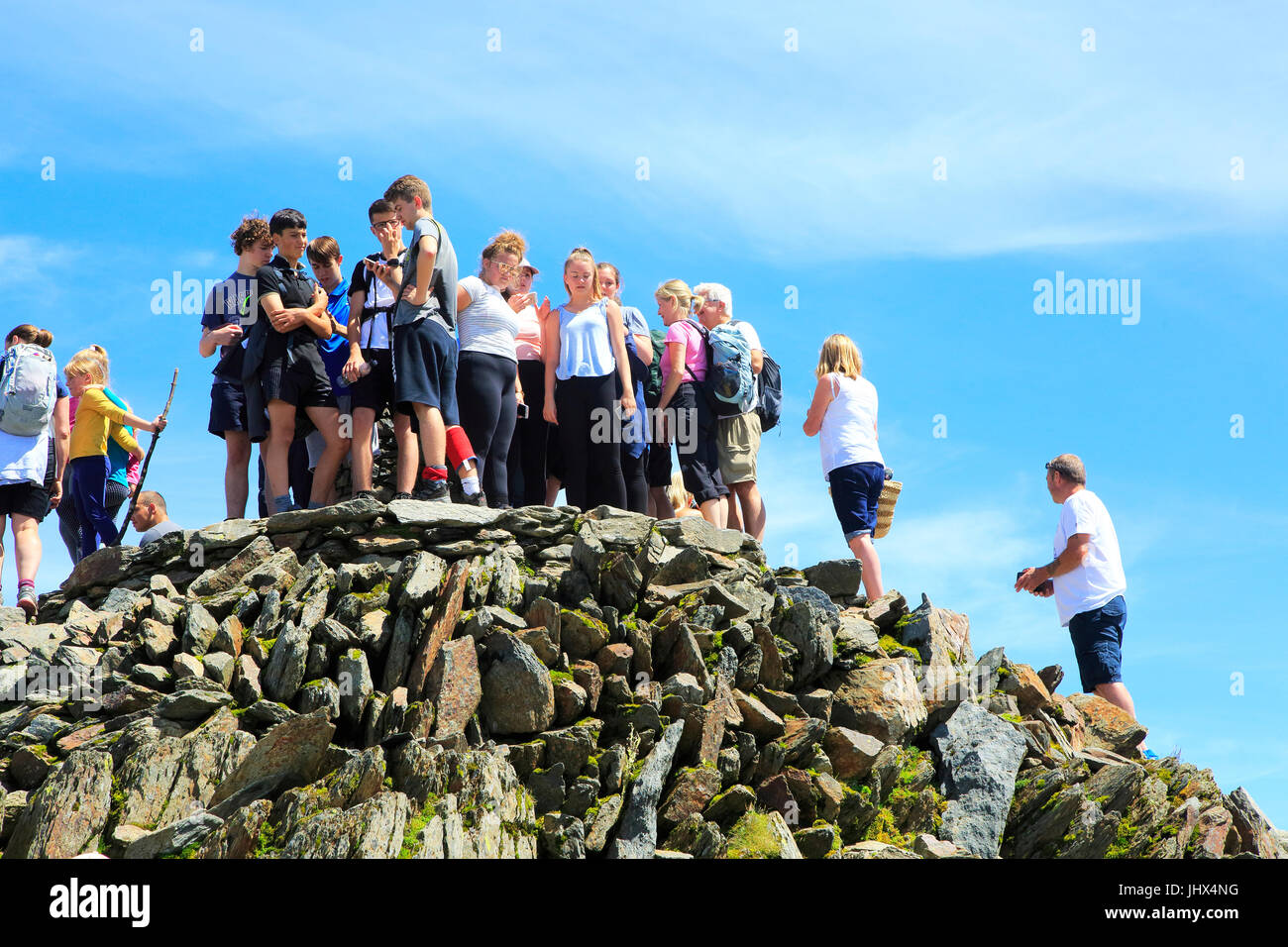 Walkers crowd onto the summit point, Mount Snowdon, Gwynedd, Snowdonia ...
