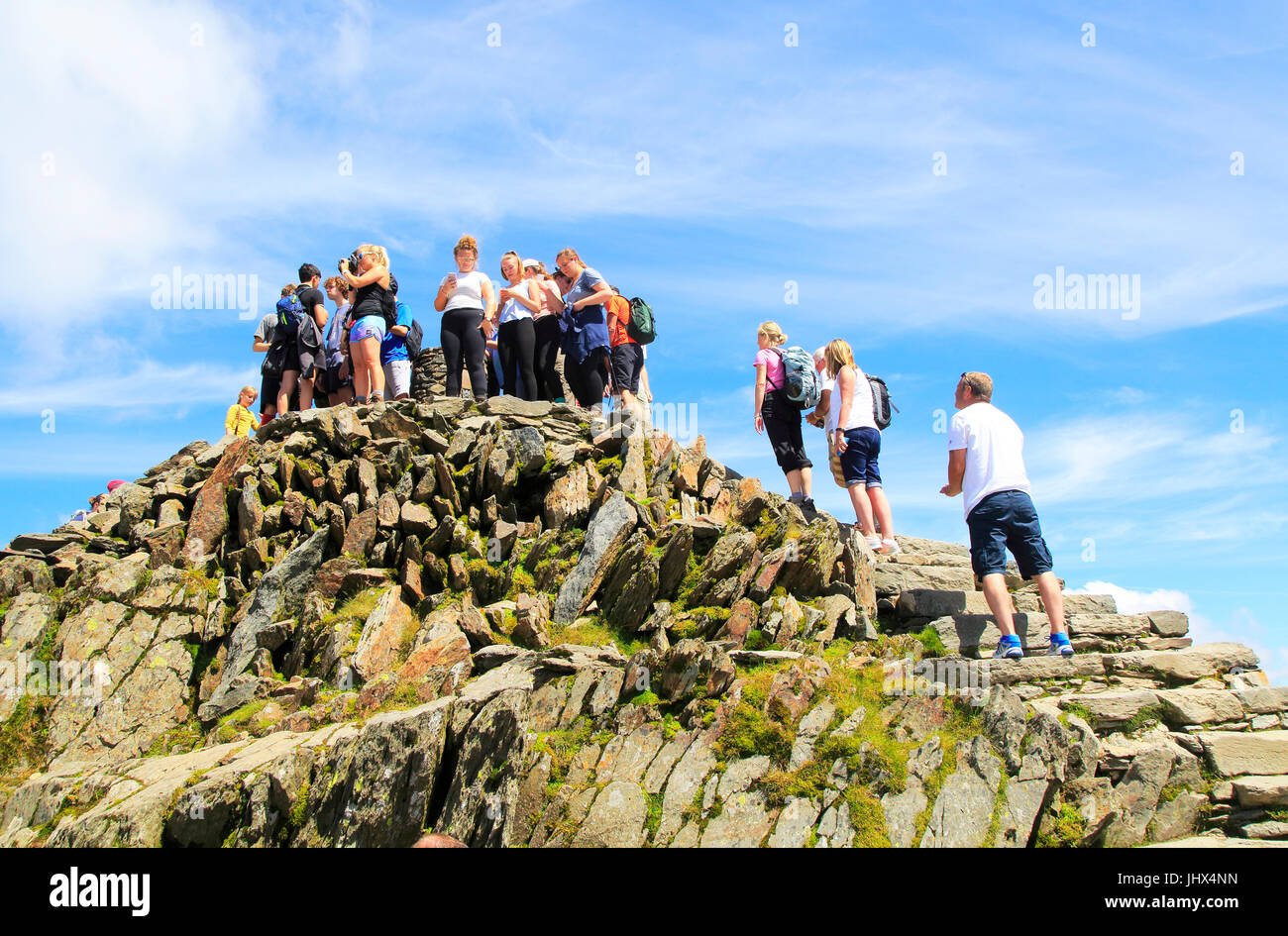 Walkers crowd onto the summit point, Mount Snowdon, Gwynedd, Snowdonia ...