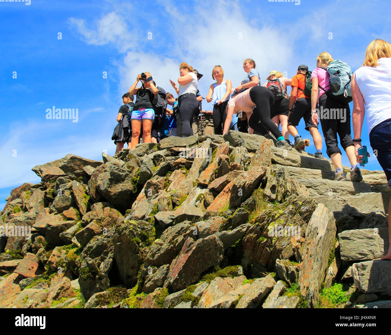 Walkers crowd onto the summit point, Mount Snowdon, Gwynedd, Snowdonia ...