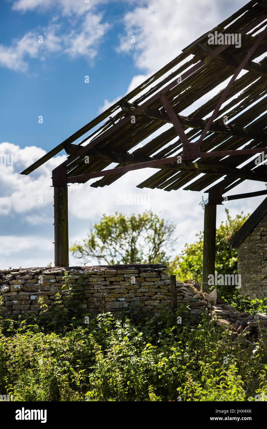 An old run down barn in a farmer's field with broken roof and old stone ...