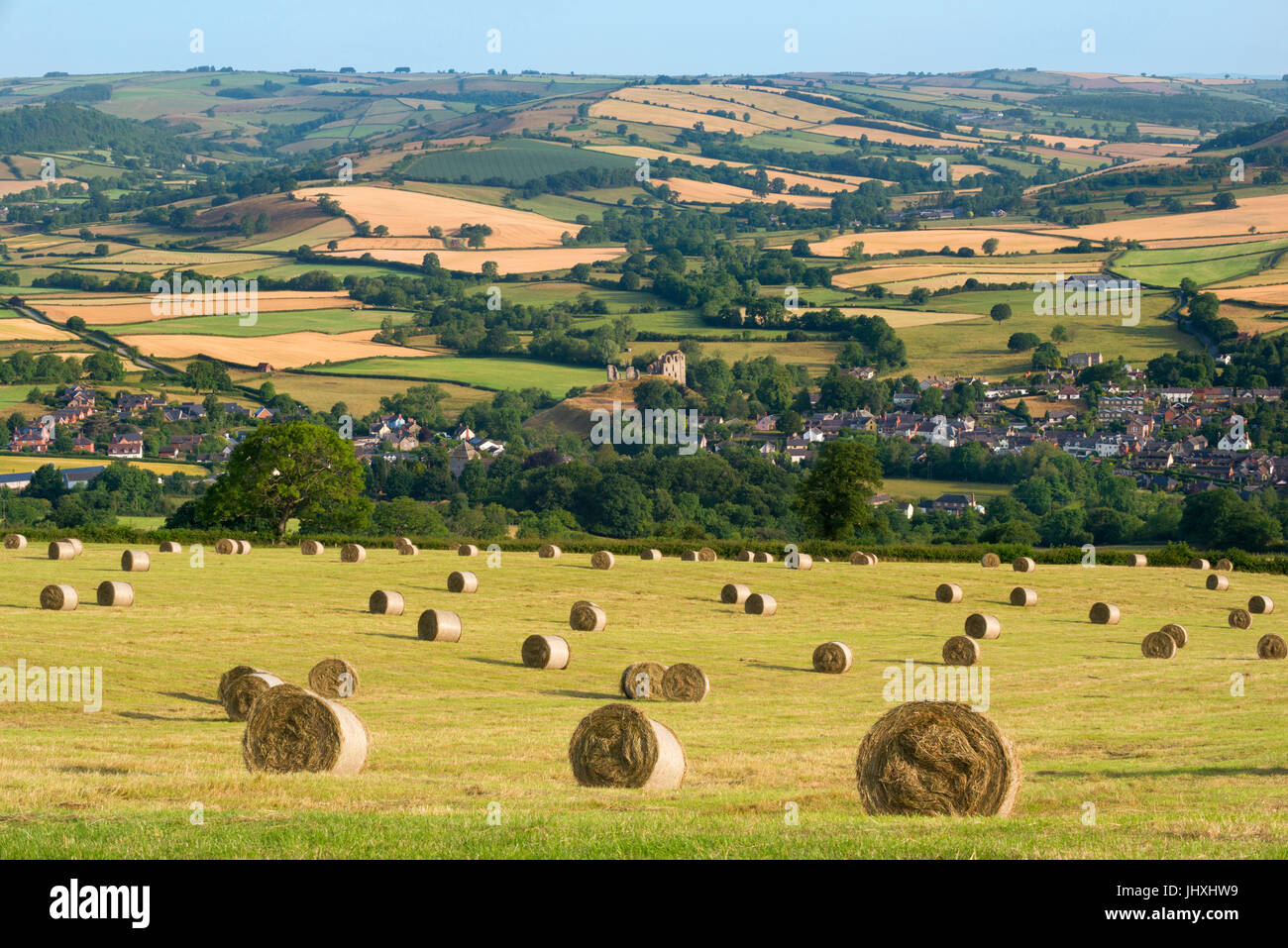 Summer scene in the Clun Valley with a field of hay bales overlooking ...