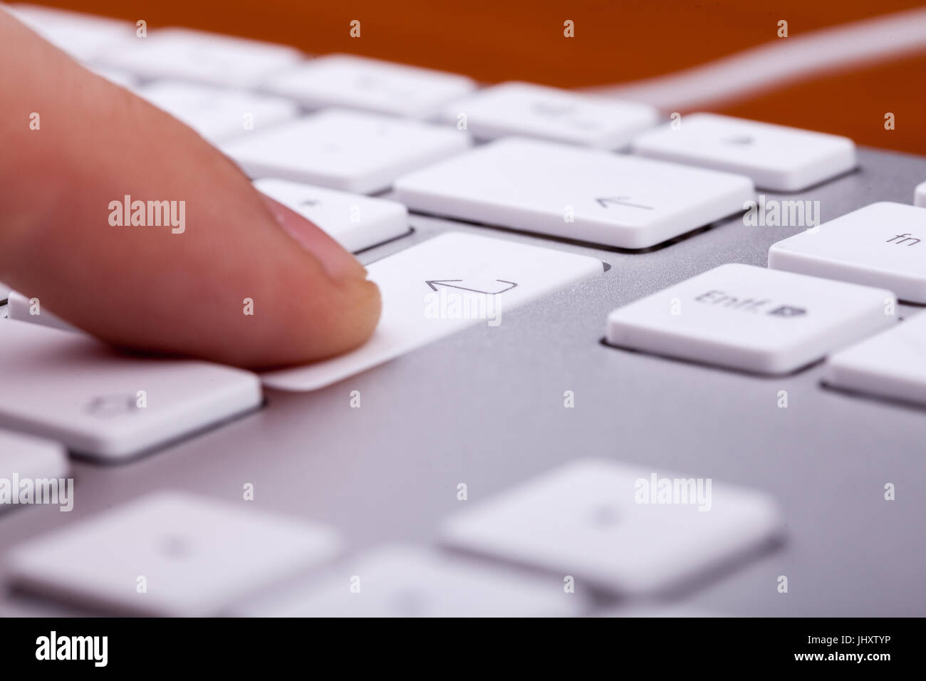 Finger pressing on keyboard Stock Photo - Alamy