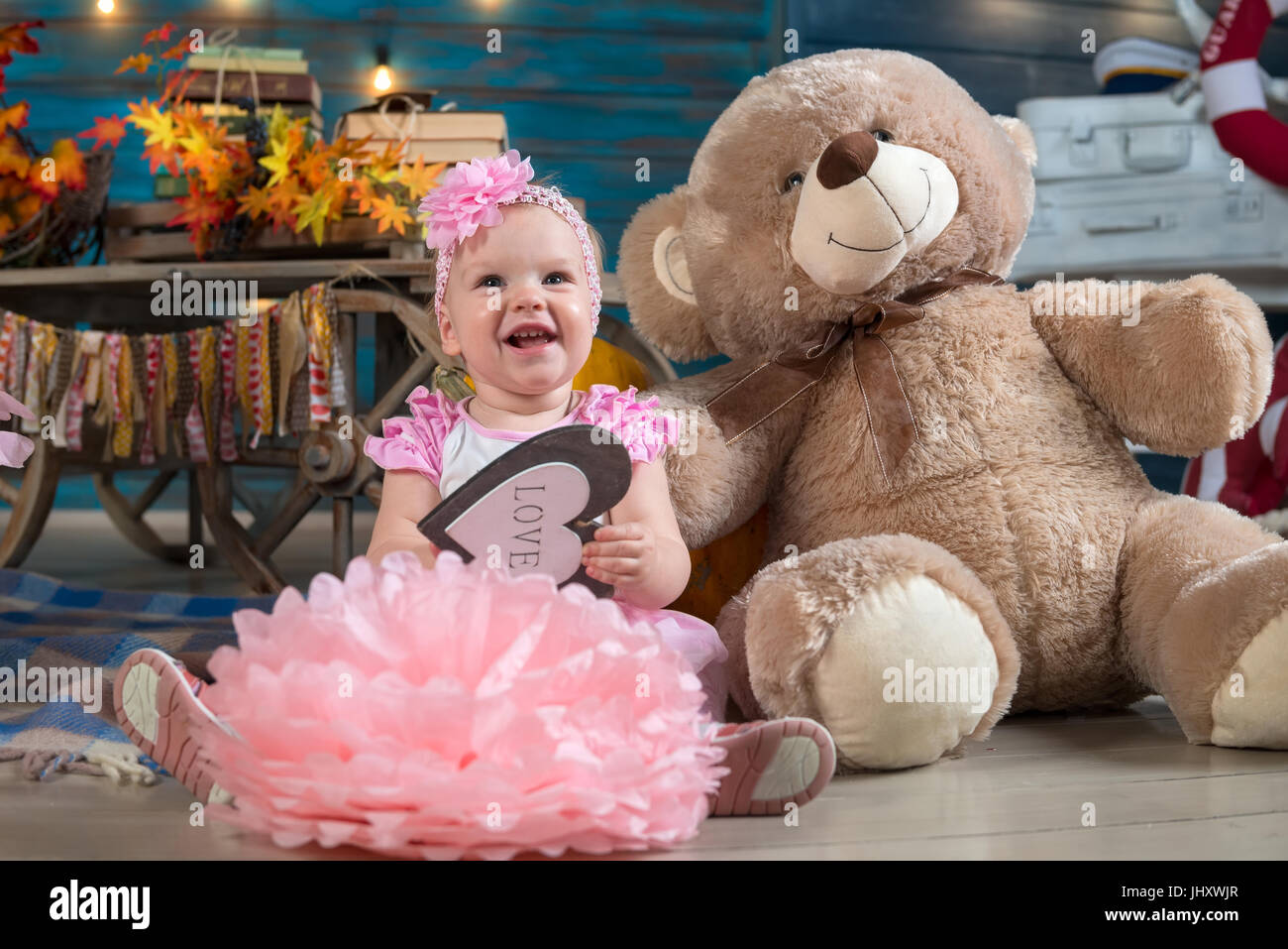 Happy one year old baby girl in autumn interior Stock Photo - Alamy