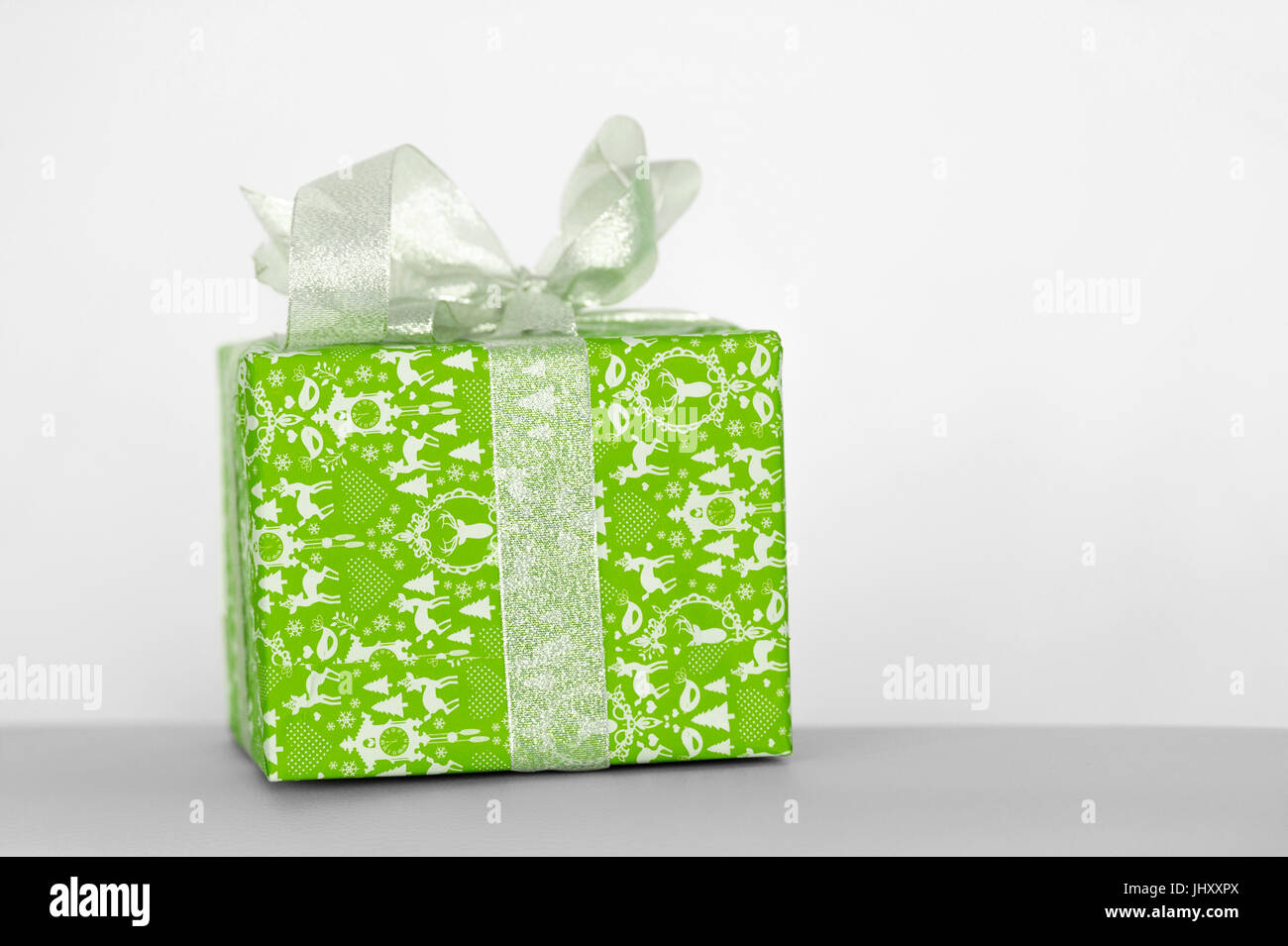 Green gift box with ribbon on white background Stock Photo - Alamy