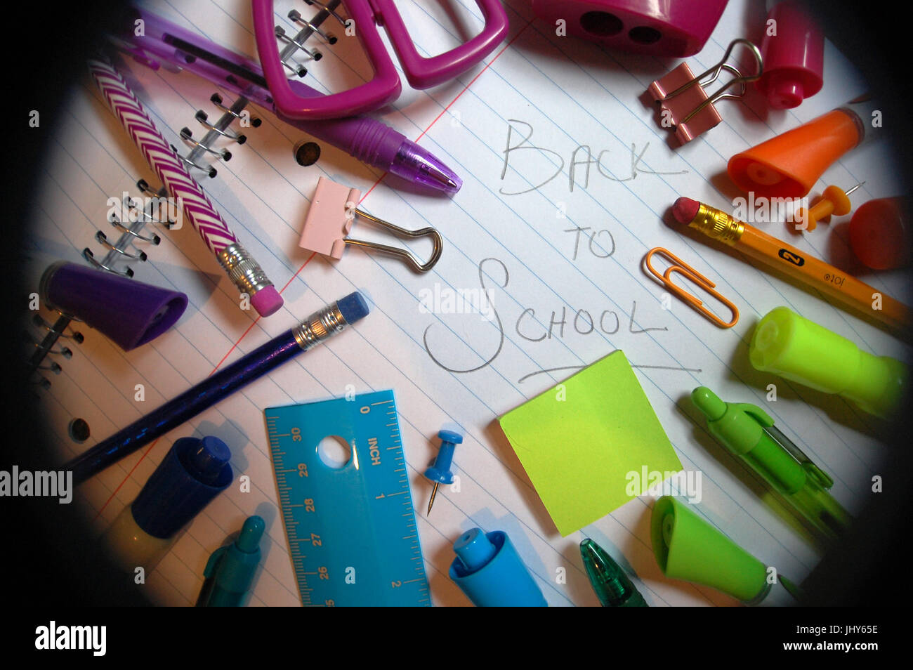 A colorful array of school supplies scattered around a wide-ruled ...
