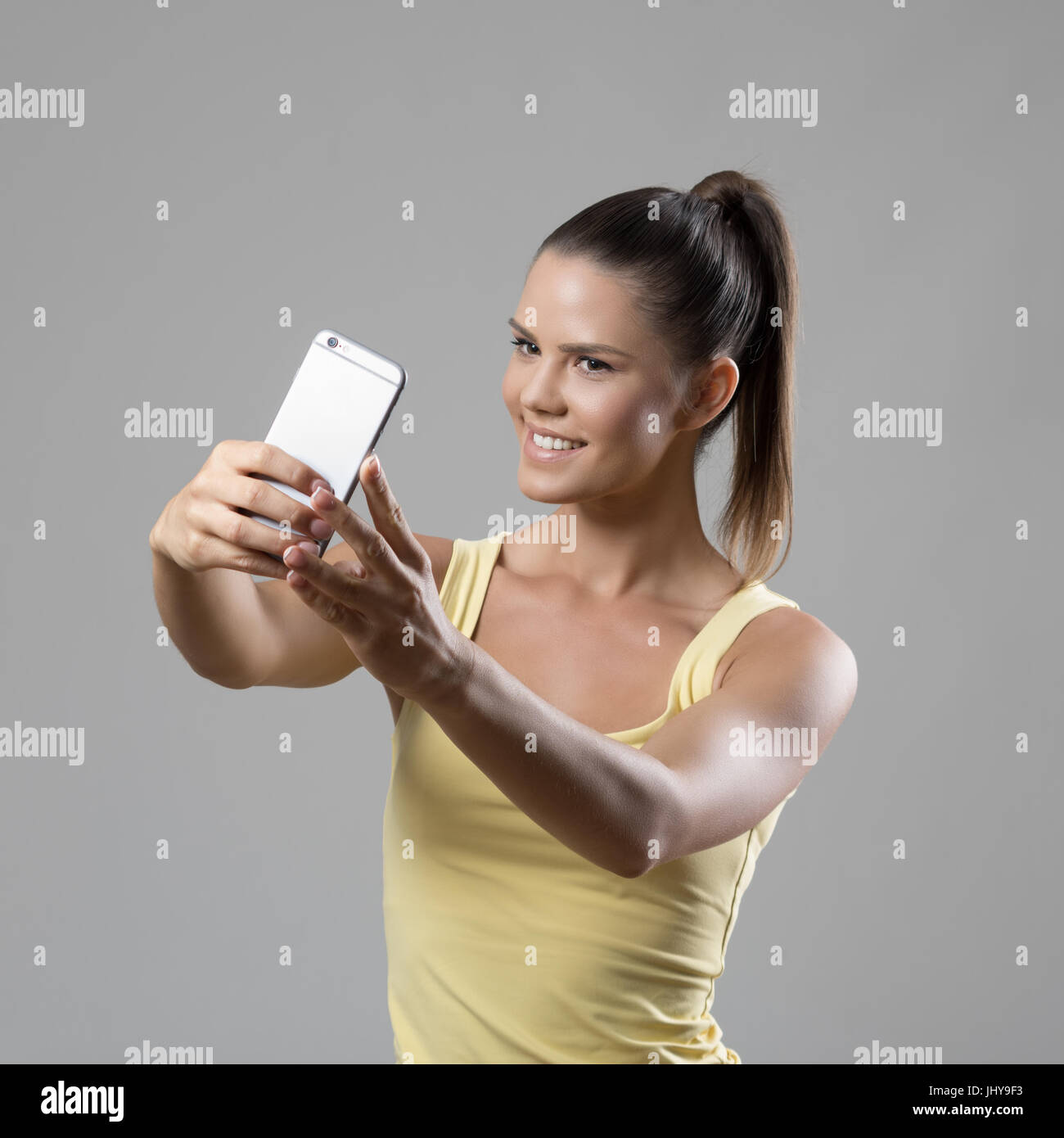 Young happy sporty woman taking selfie self portrait with smart phone ...
