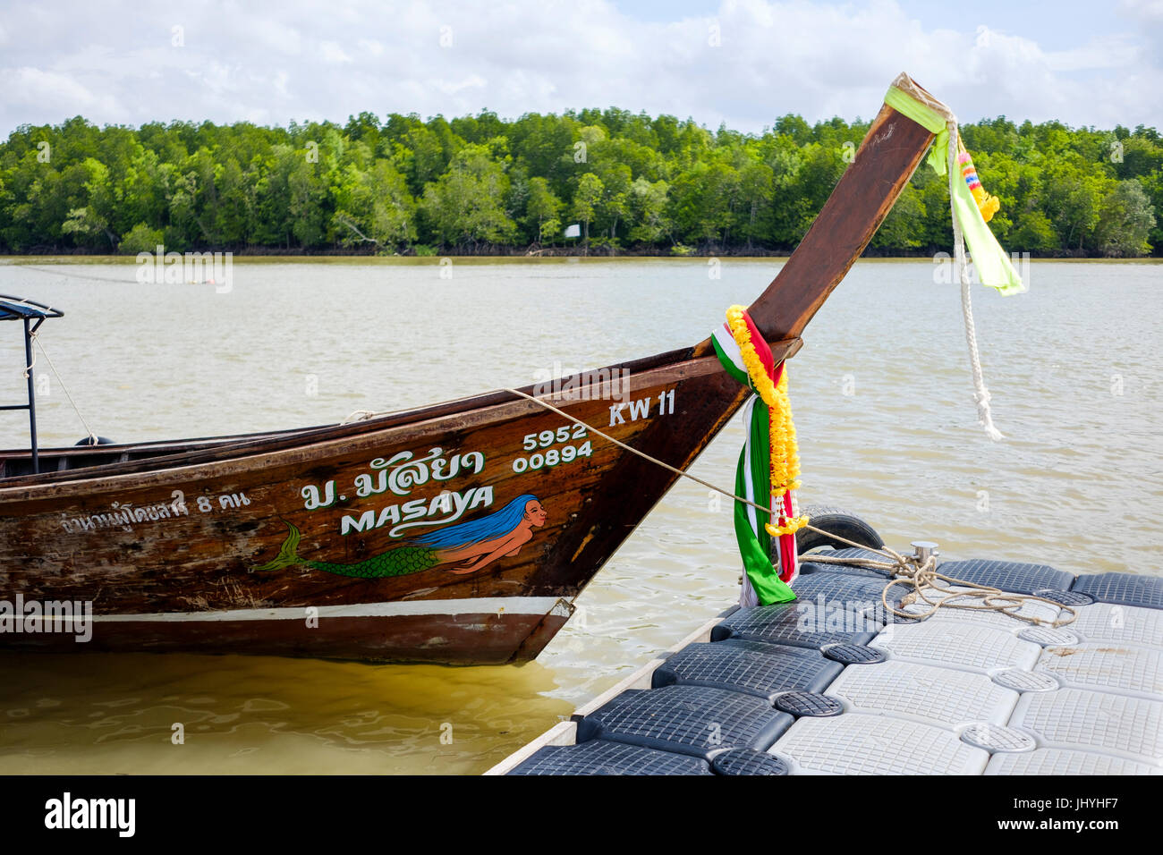 Bow of a moored, Thai longtail boat decorated with colourful garlands ...