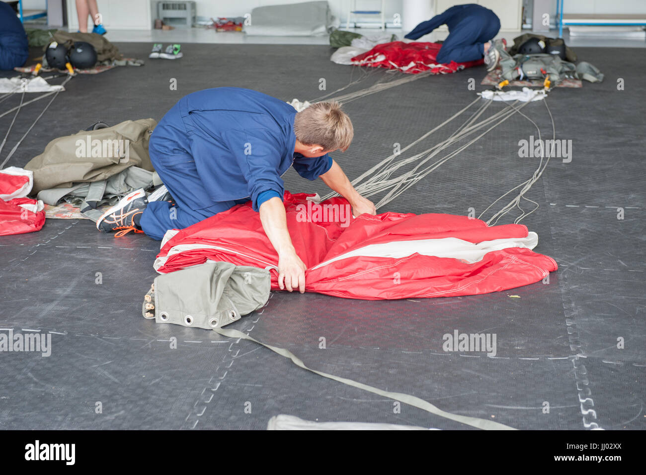 A student skydiver packing his parachute in a hangar Stock Photo - Alamy