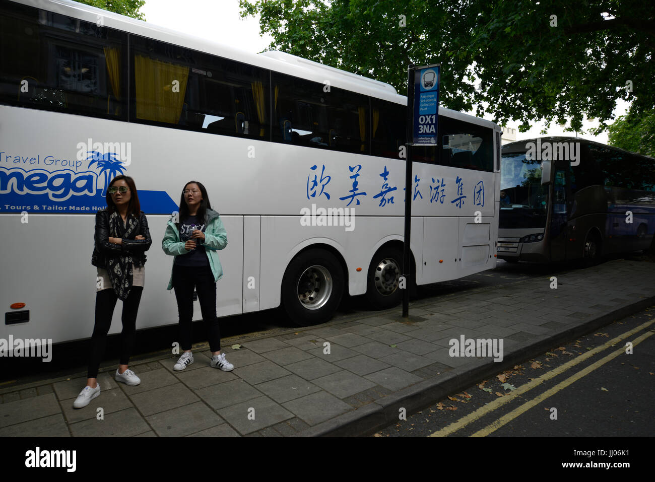 Tourist bus with Chinese lettering and logos deposits passengers in ...