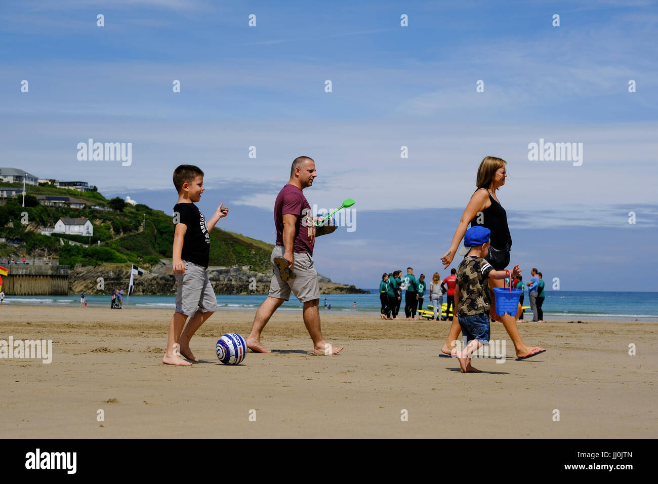 Family head towards the sea on the beach at Newquay in Cornwall Stock ...