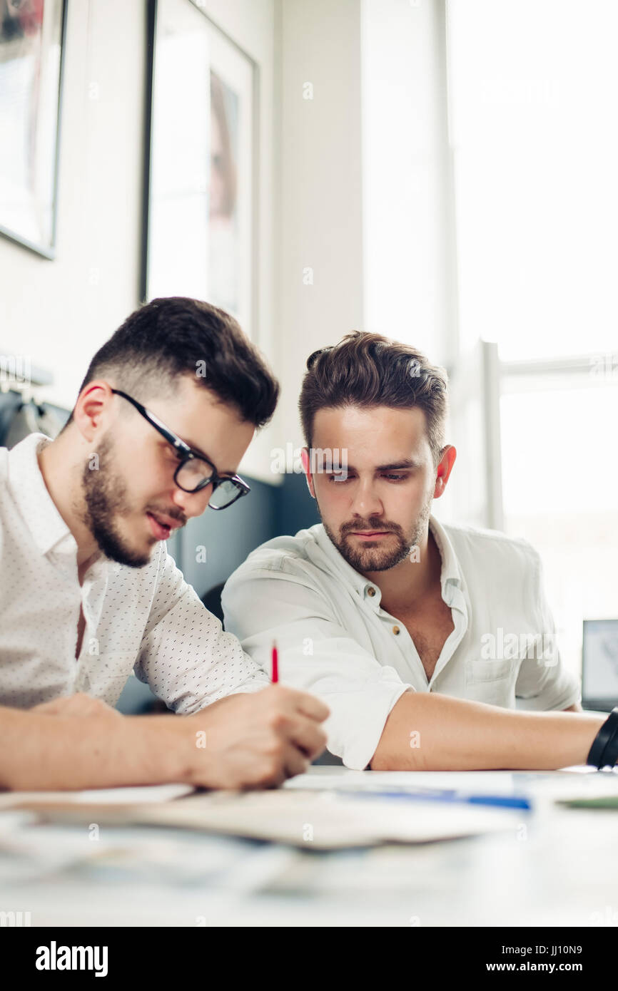 two handsome men architect looking at plans Stock Photo - Alamy