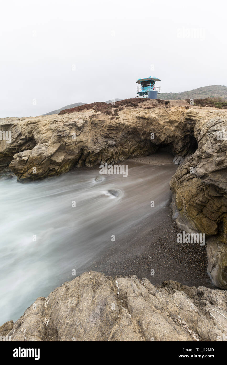 Rocky cove with motion blur water below lifeguard tower at Leo Carrillo ...