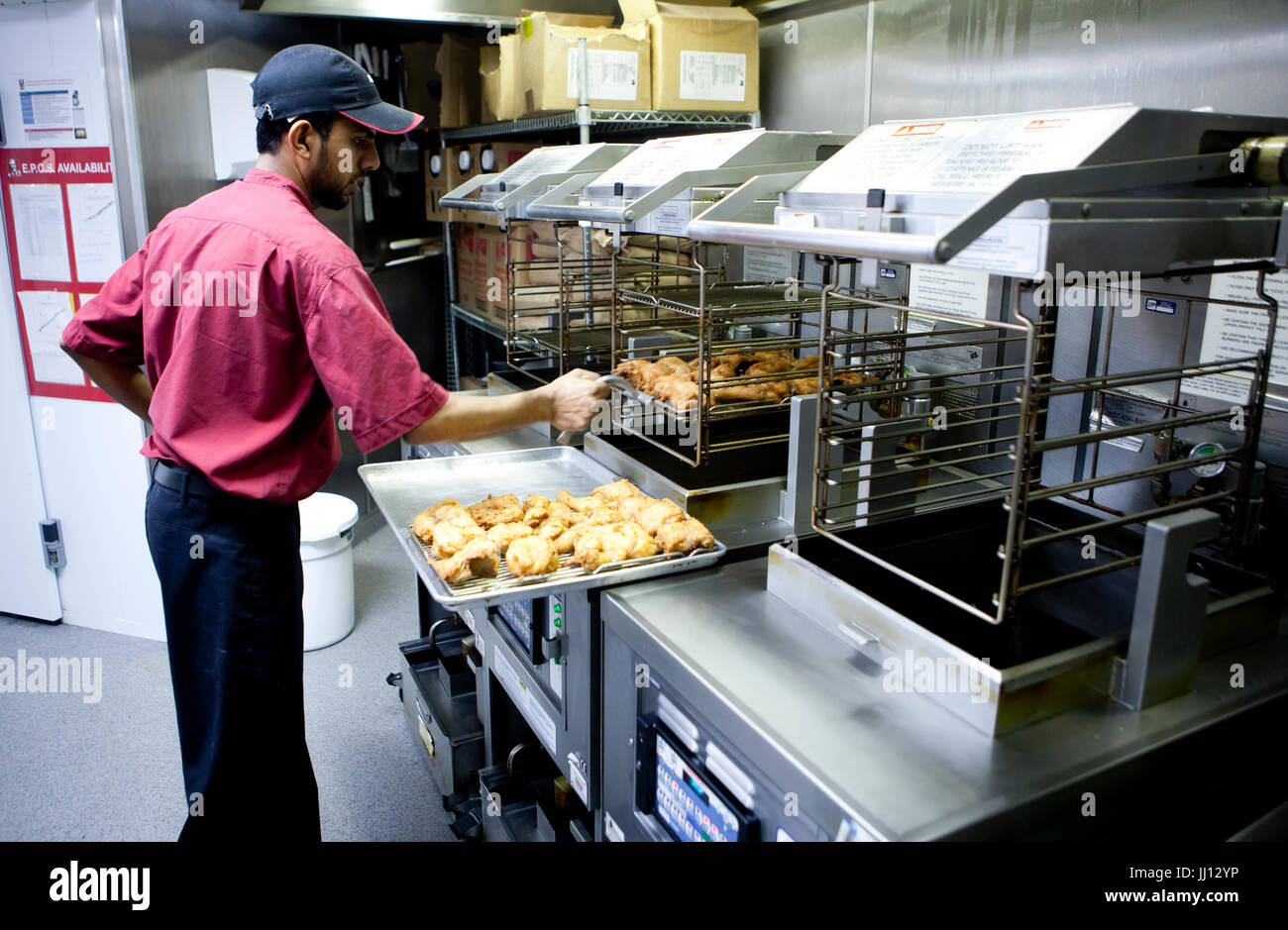 A member of staff prepares fried chicken at a KFC in England, UK Stock ...