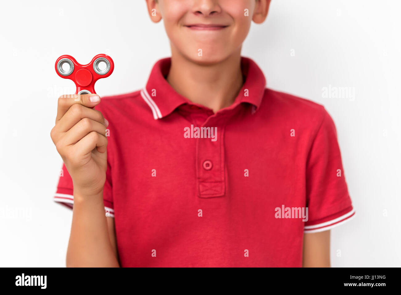 Red hand spinner. Boy playing a popular toy fidget spinner in his hand ...