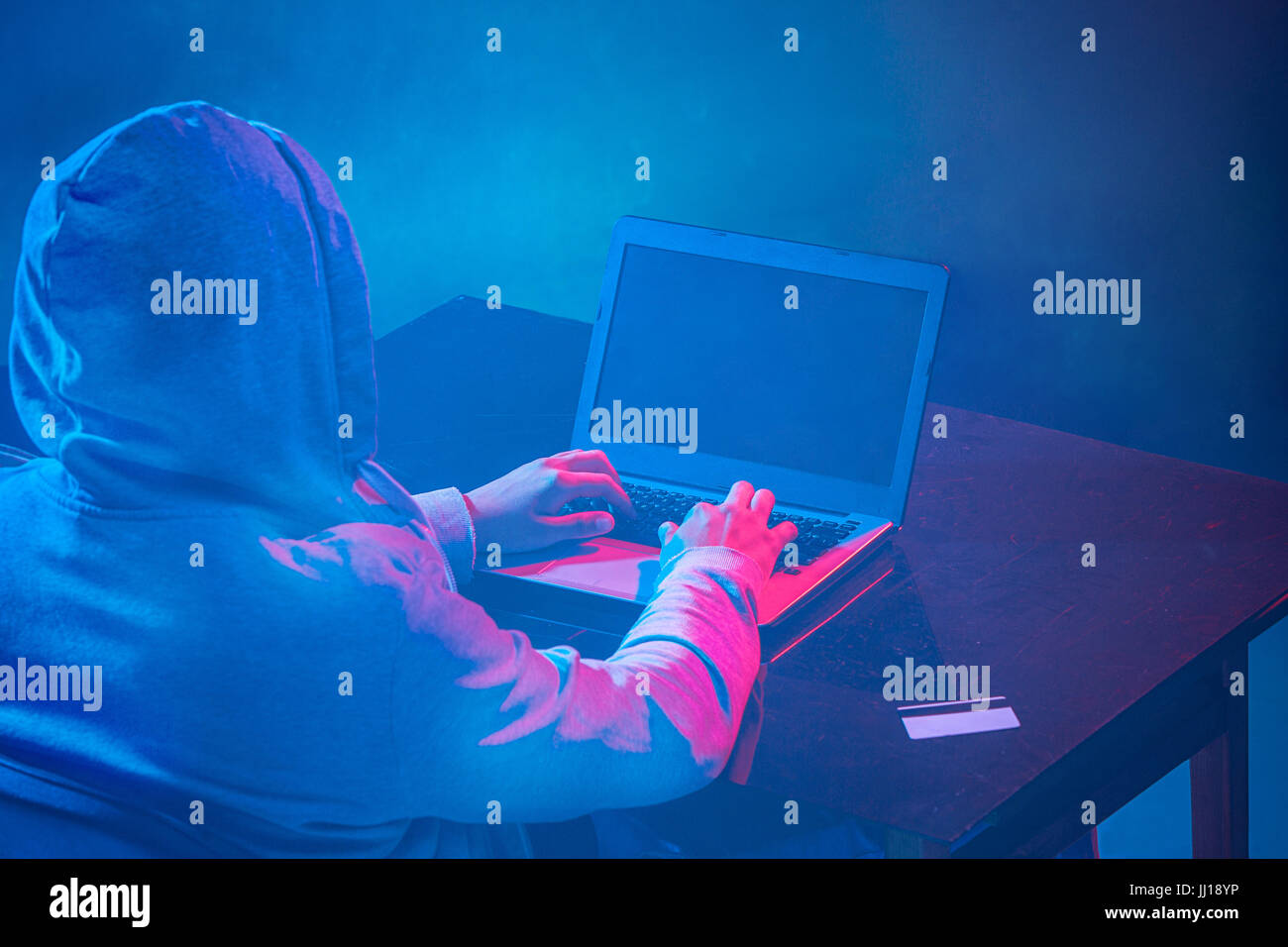 Hooded computer hacker stealing information with laptop Stock Photo - Alamy