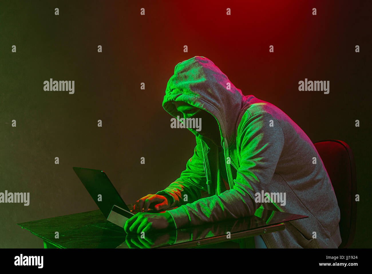 Hooded computer hacker stealing information with laptop Stock Photo - Alamy