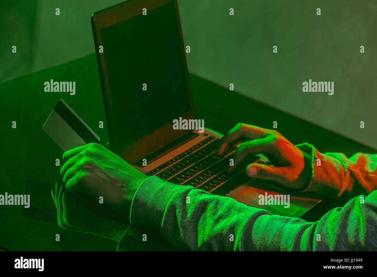 Hooded computer hacker stealing information with laptop Stock Photo - Alamy