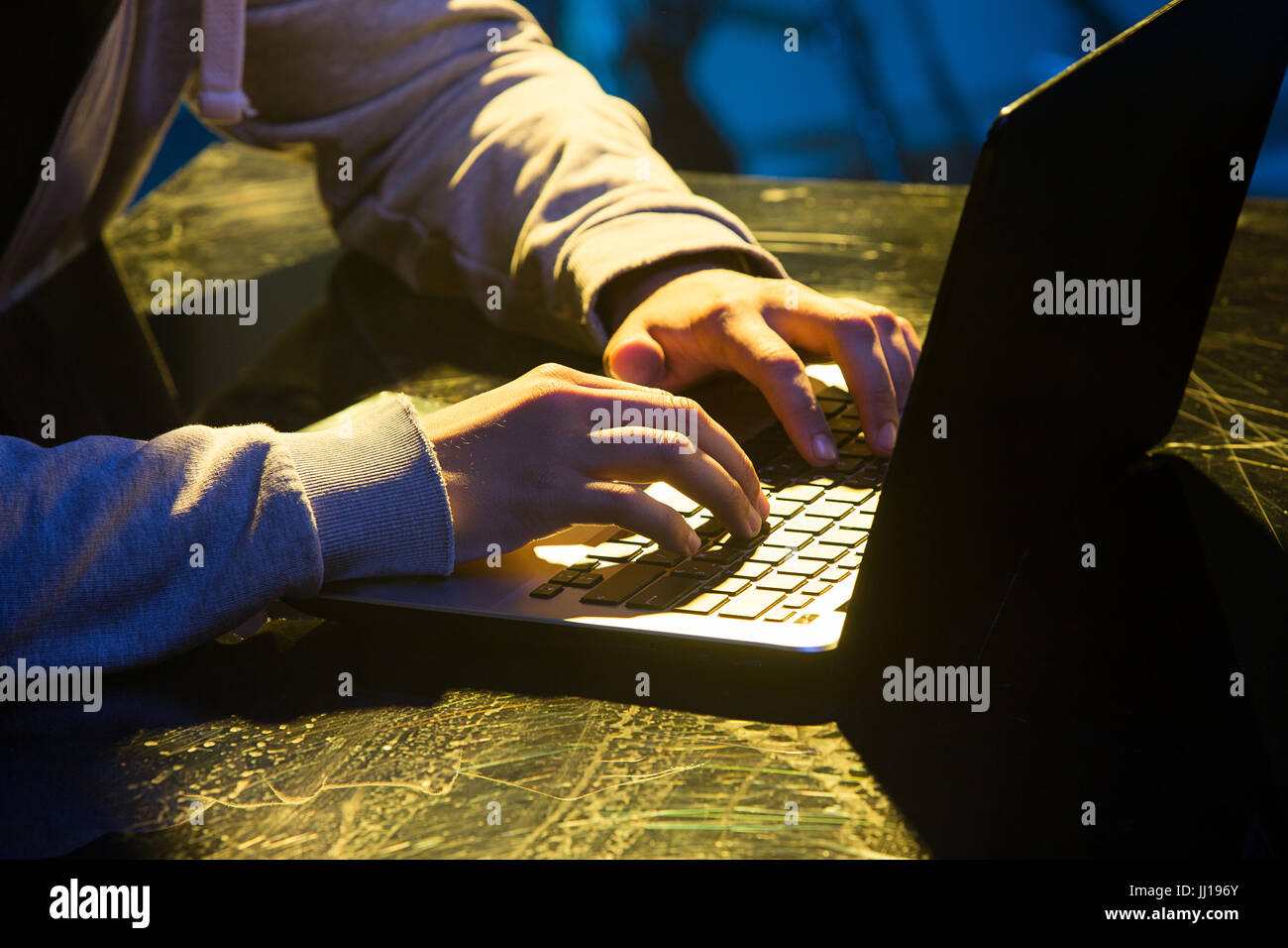 Hooded computer hacker stealing information with laptop Stock Photo - Alamy
