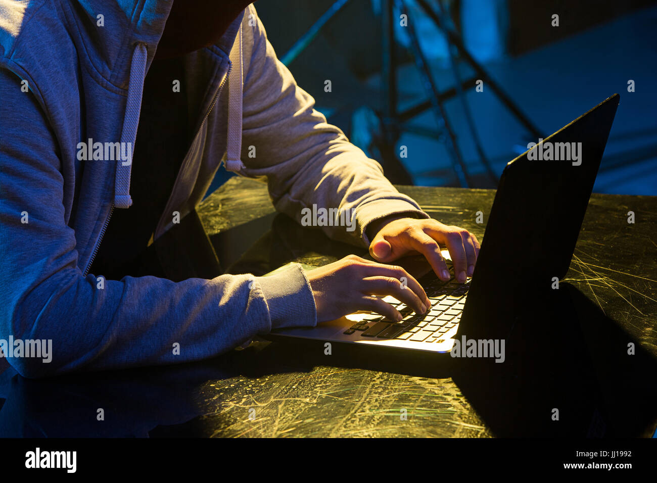 Hooded computer hacker stealing information with laptop Stock Photo - Alamy