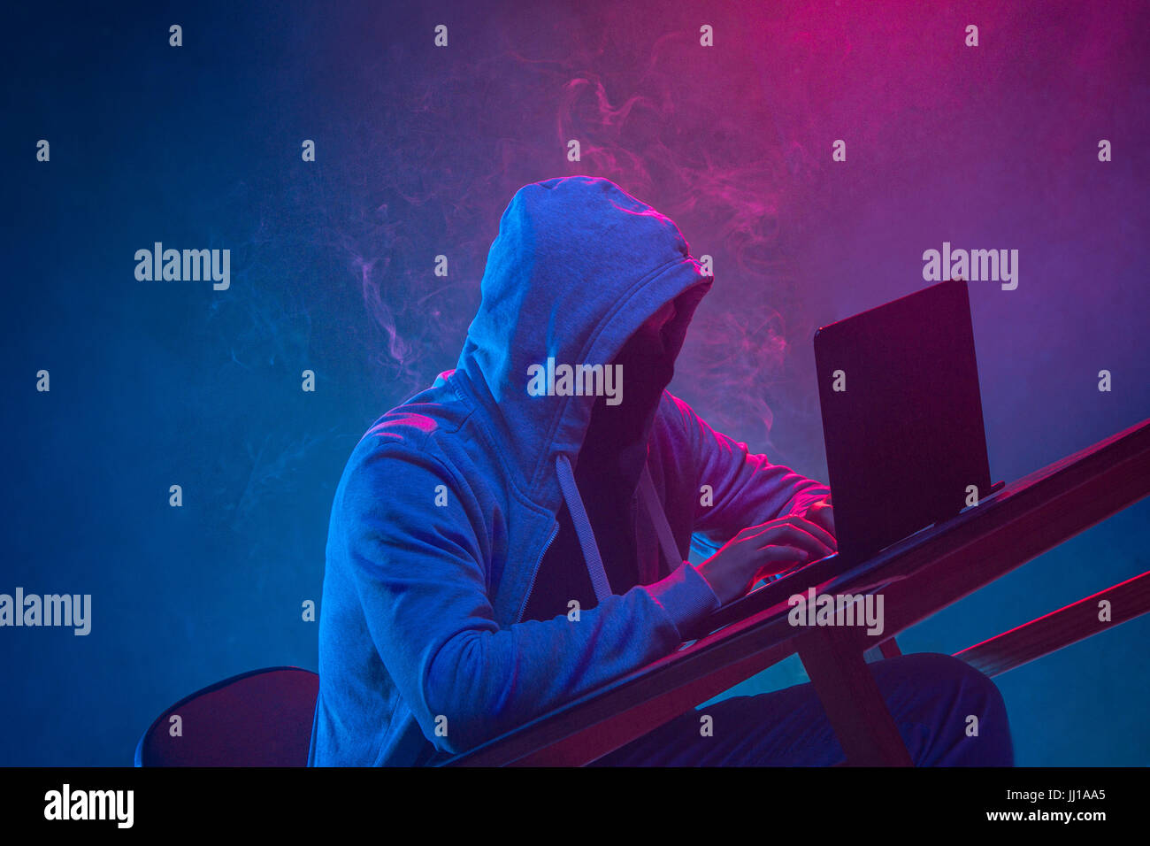 Hooded computer hacker stealing information with laptop Stock Photo - Alamy
