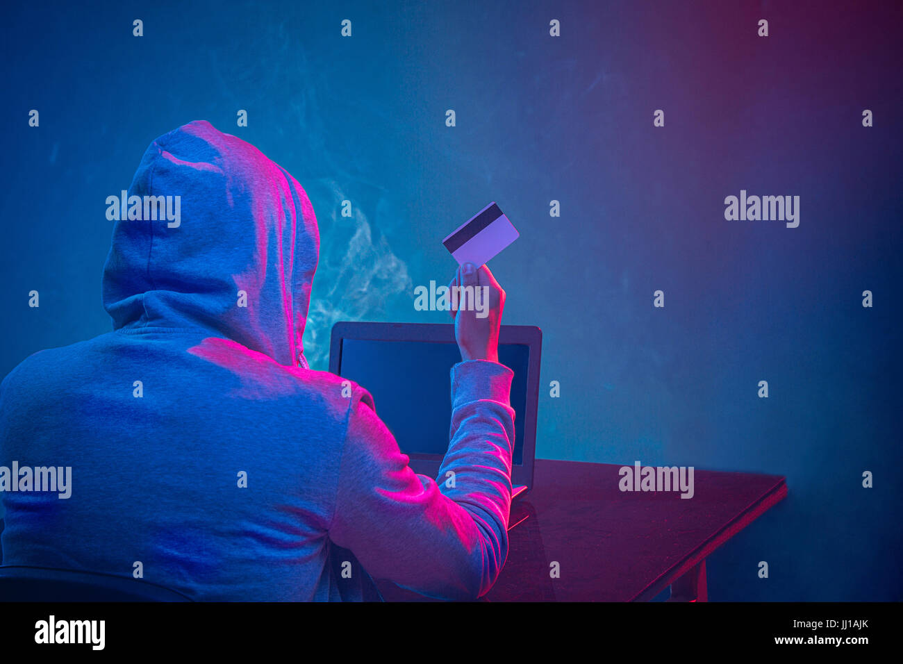 Hooded computer hacker stealing information with laptop Stock Photo - Alamy