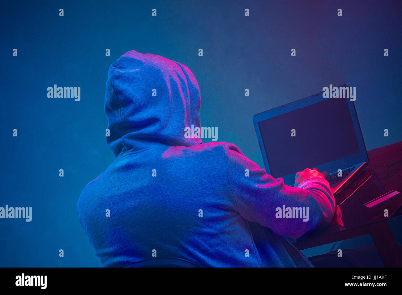 Hooded computer hacker stealing information with laptop Stock Photo - Alamy