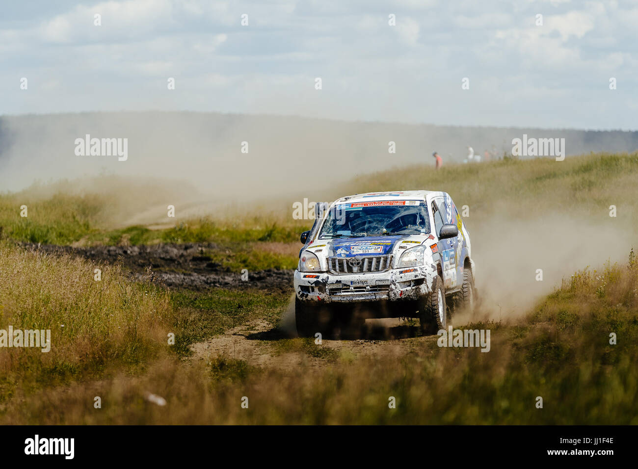 rally car Toyota driving on a dust road among grass during Silk way ...