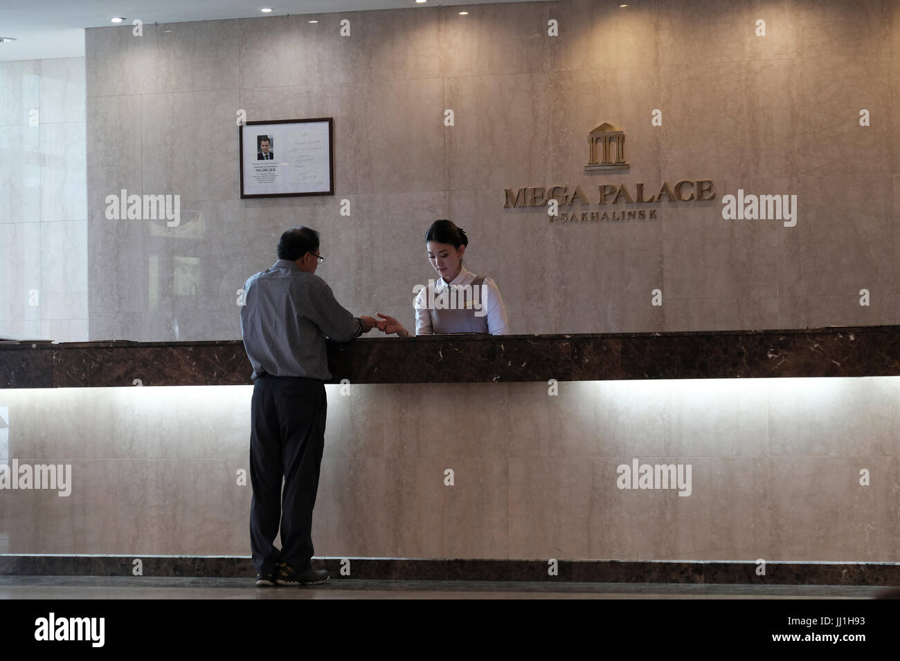 A hotel front desk agent registers a guest at the reception desk of Mega Palace hotel in the ...