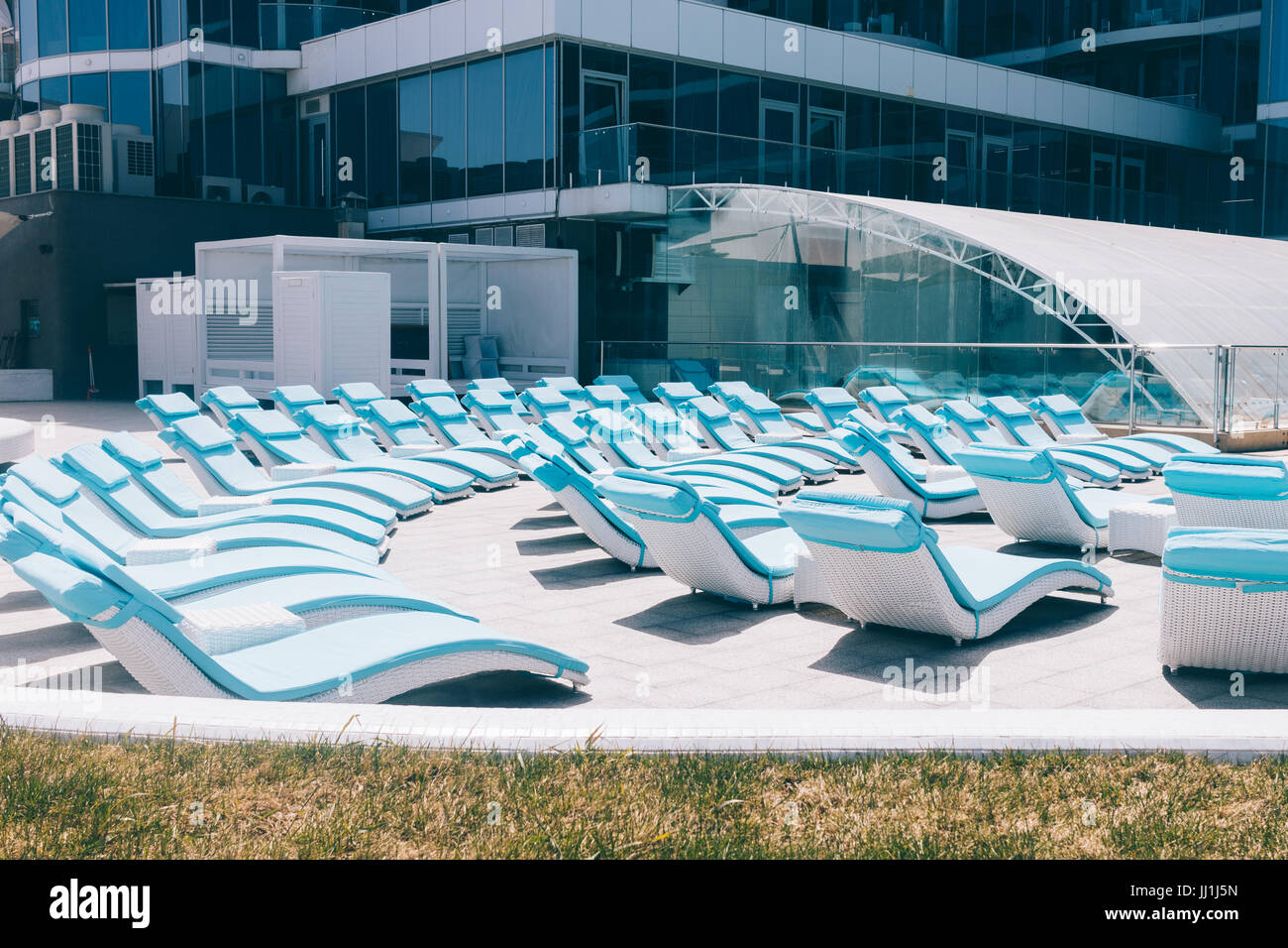 Empty blue sunbeds in a summer resort outdoors Stock Photo - Alamy