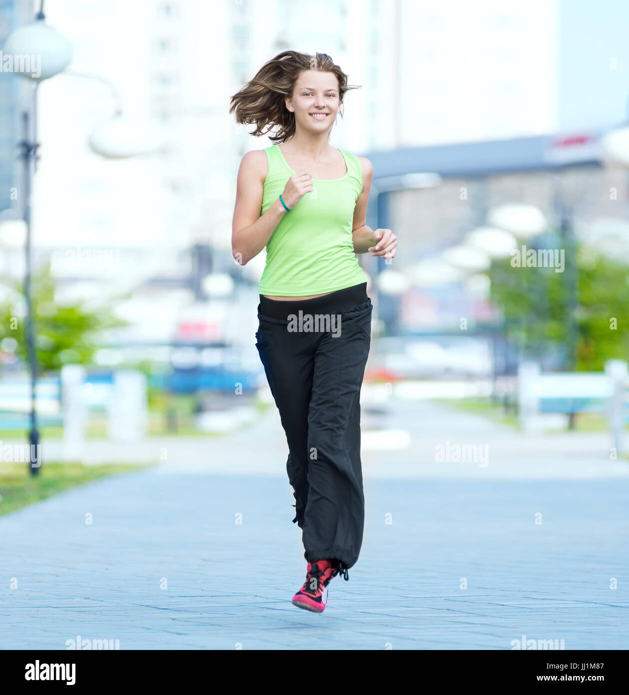 Woman jogging in city street park Stock Photo - Alamy