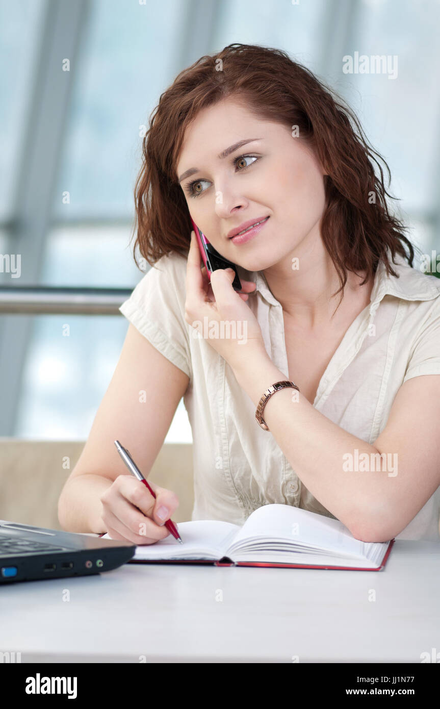 Business woman on phone taking notes Stock Photo - Alamy