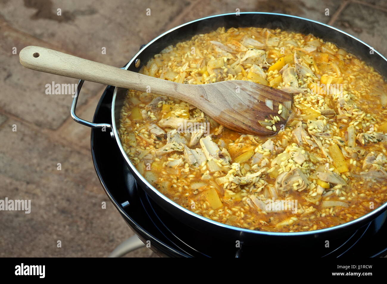 Pan of chicken paella cooking on an outdoor gas cooker Stock Photo - Alamy