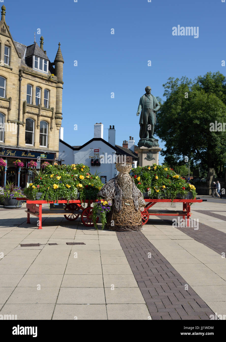 Bury in bloom display, wicker flower seller with flower covered hand ...