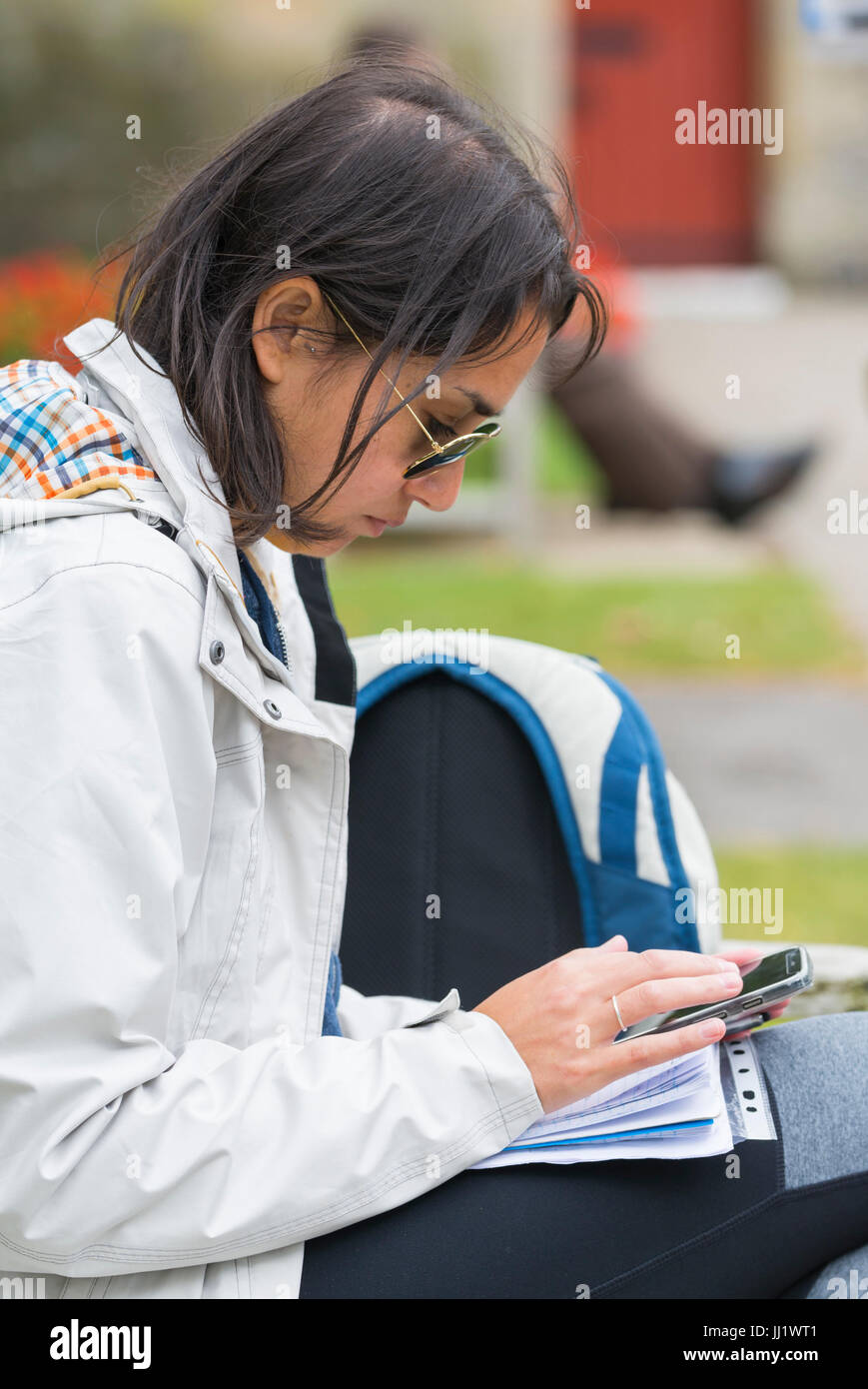 Woman sitting down using her smartphone. Sitting texting Stock Photo ...