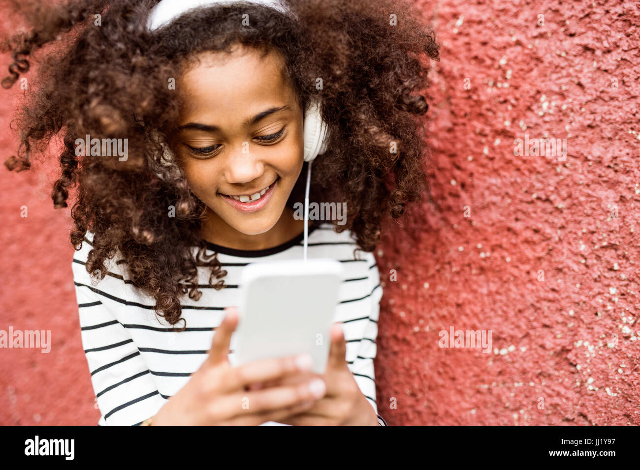 Beautiful african american girl with smart phone and earphones Stock ...