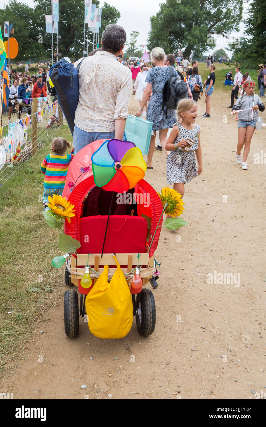 Bright red baby trailer with sunflowers and rainbow wondmill being ...