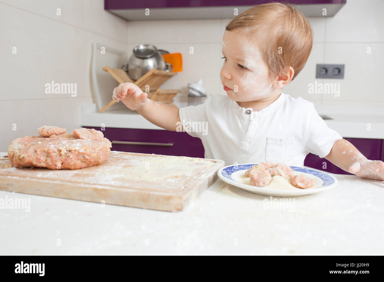Baby boy preparing meatballs. He is kneading the balls Stock Photo - Alamy