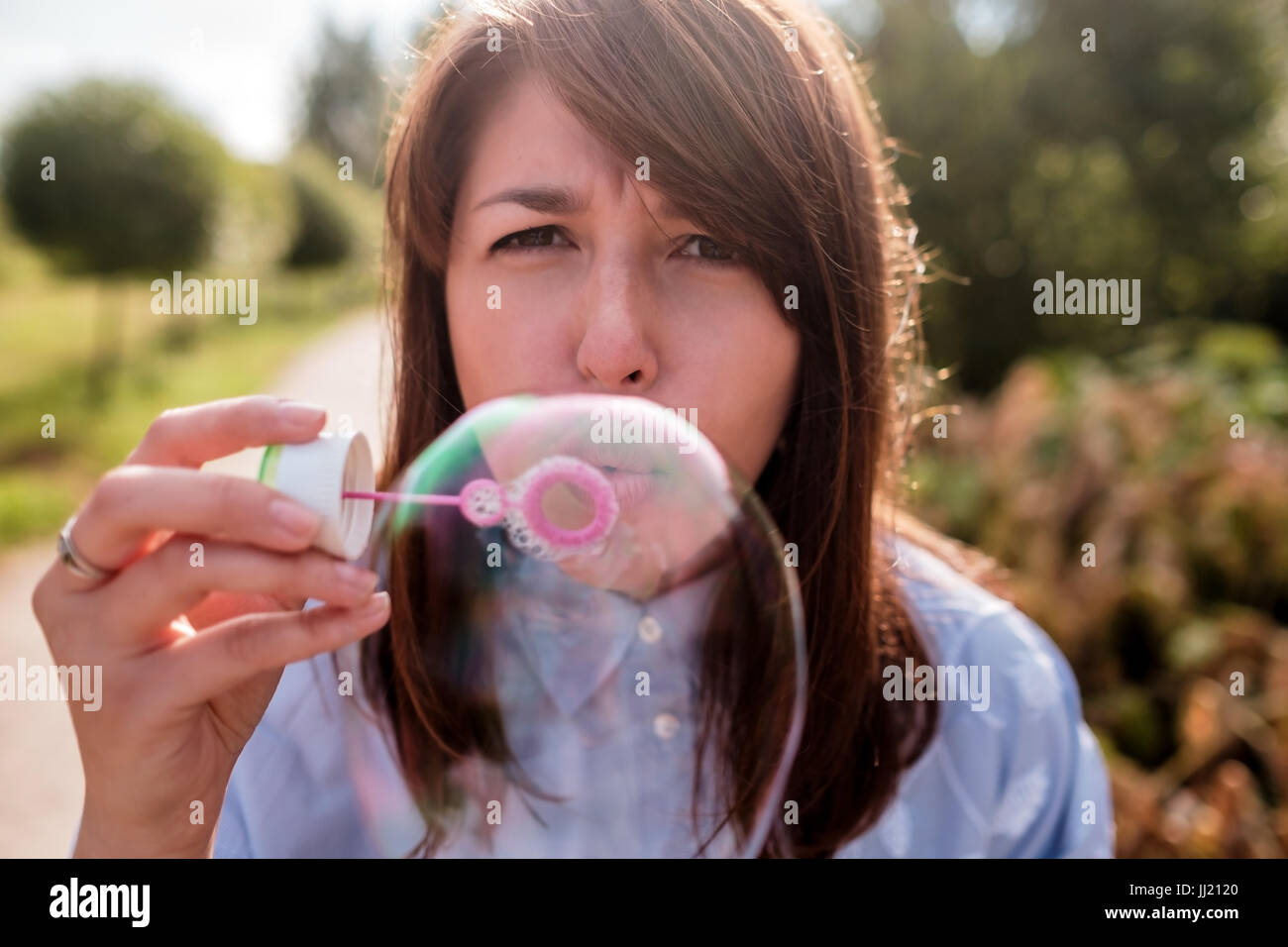 Girl blowing bubbles outdoor. Focus on lips Stock Photo - Alamy