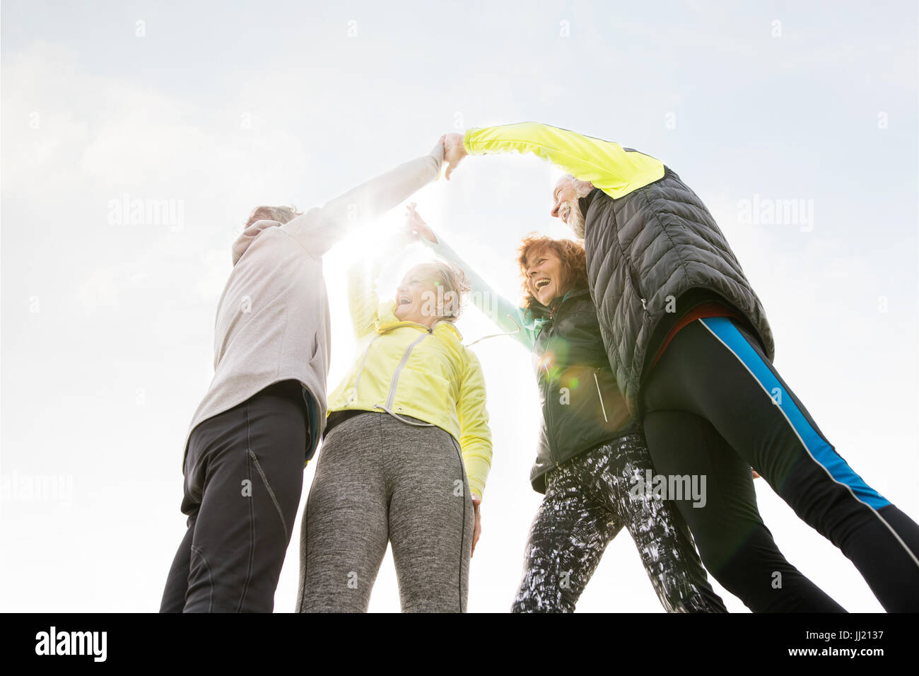 Group of senior runners outdoors, resting, holding hands Stock Photo ...