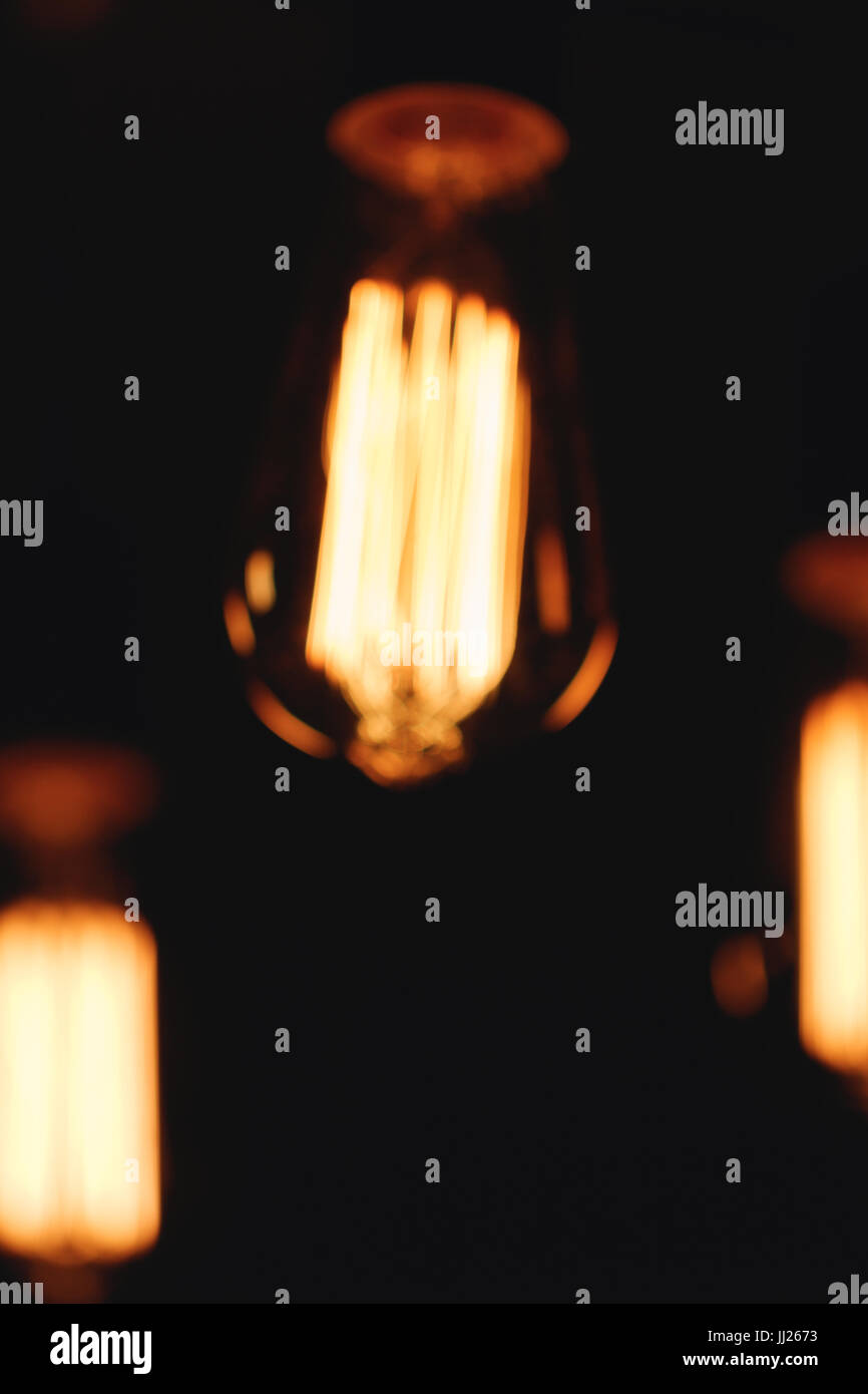 Blurred image of glowing retro light bulbs at night Stock Photo - Alamy
