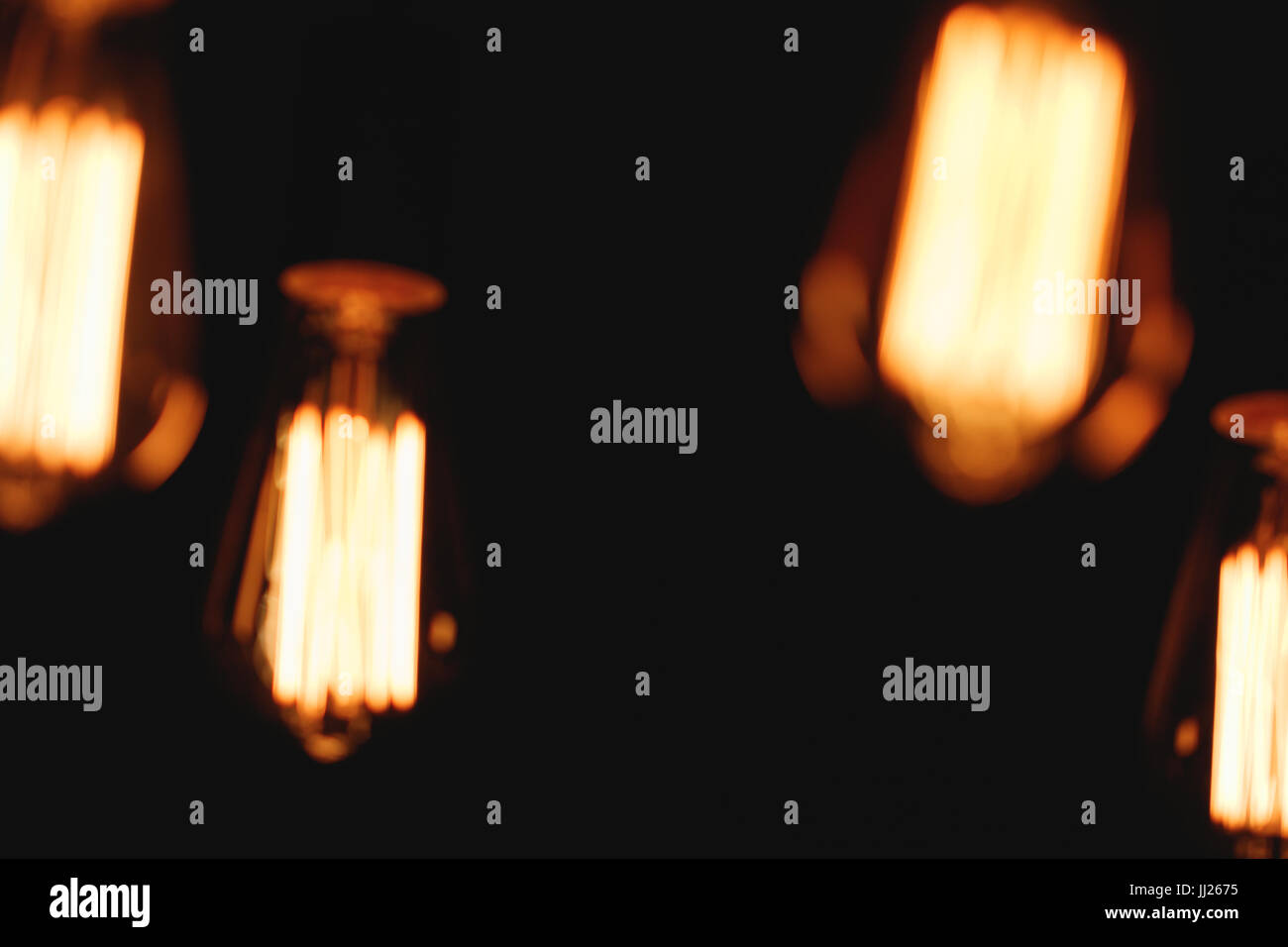 Blurred image of glowing retro light bulbs at night Stock Photo - Alamy