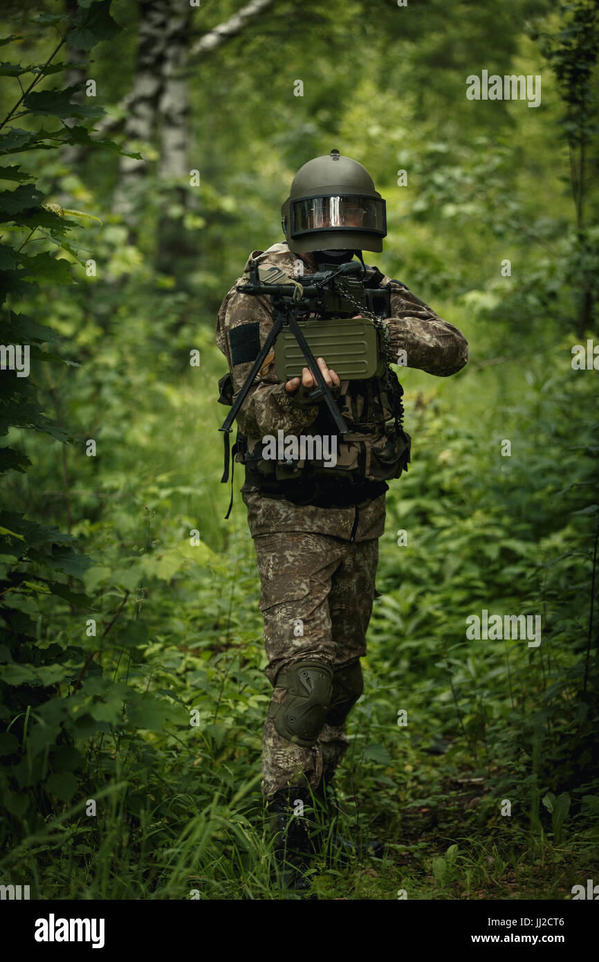 Military man with gun, helmet Stock Photo - Alamy